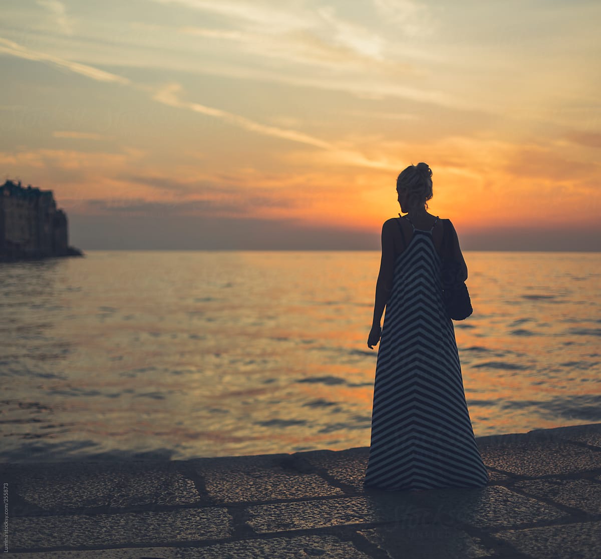 "Woman Standing By The Sea At Sunset" by Stocksy Contributor "Lumina ...