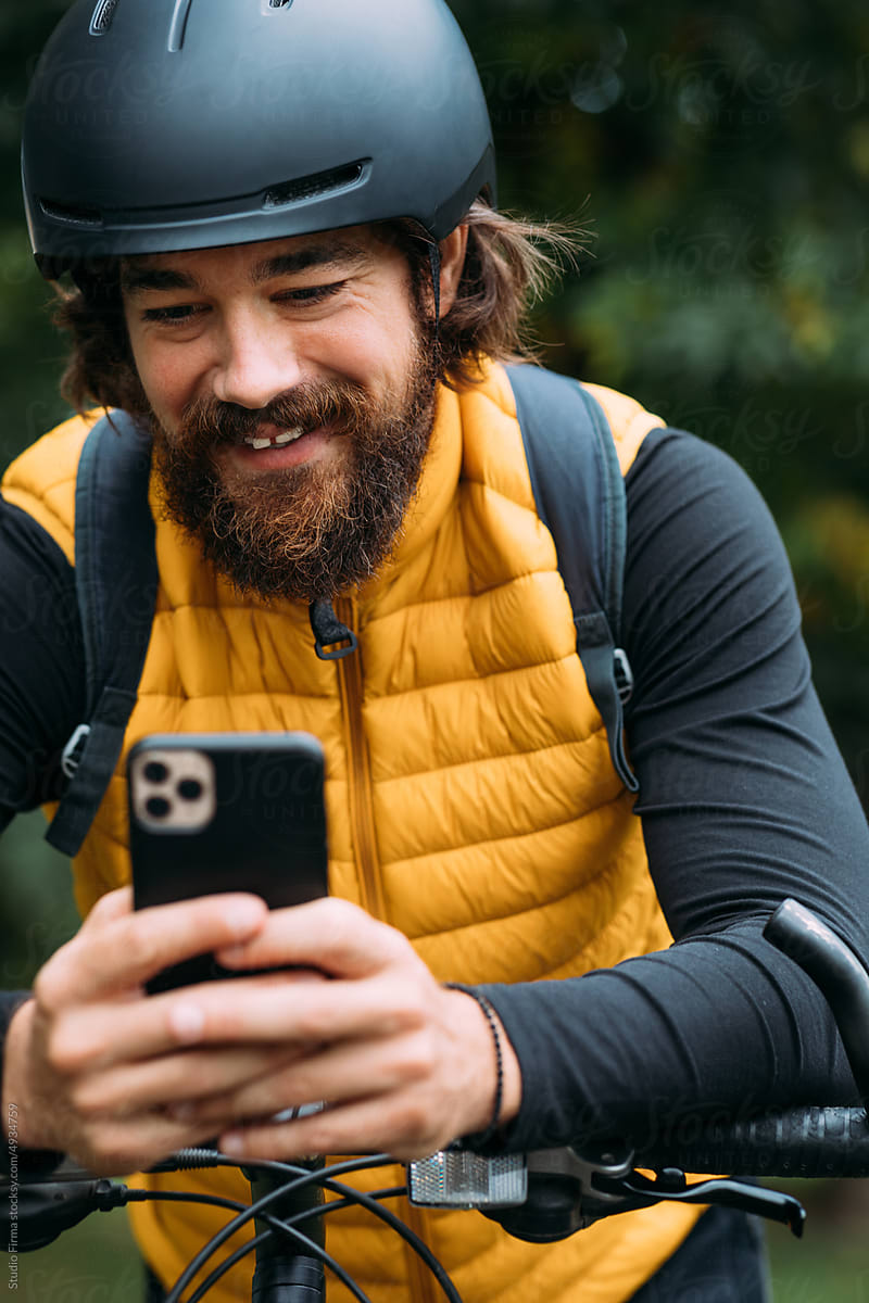 Cyclist Man Using Mobile Phone By Stocksy Contributor Studio Firma