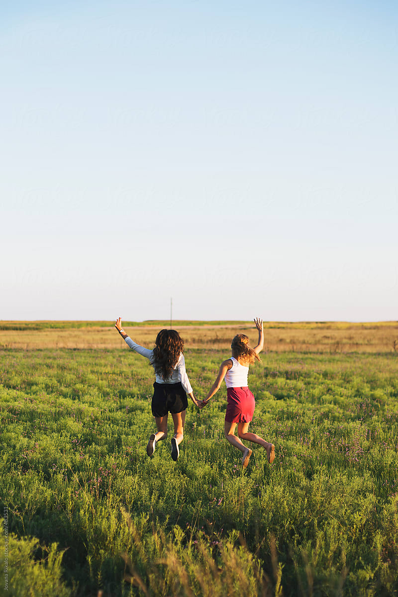 "Two Female Friends Jumping On A Field" by Stocksy Contributor "Jovana ...
