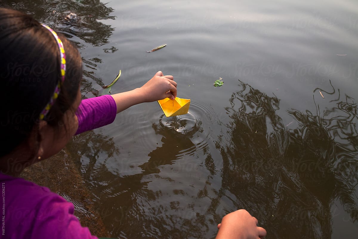 "Teenage Girl Sailing Paper Made Boat Floating On Water" by Stocksy ...