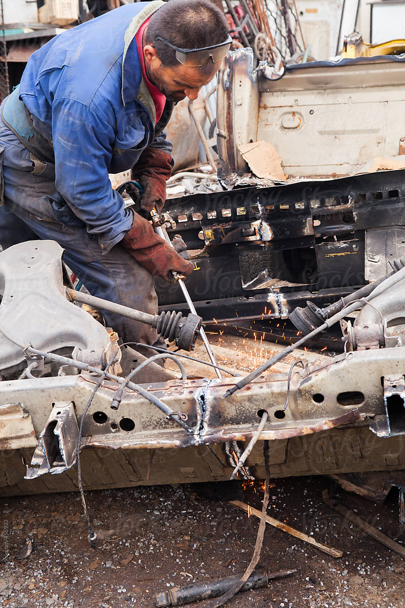 "Craftsman Cutting Parts Of Old Car On Scrpayard." by Stocksy ...