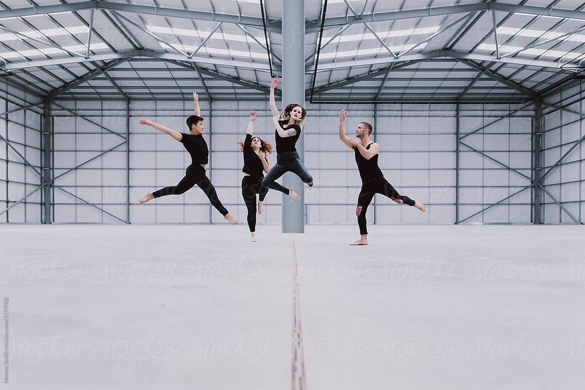 "Four Dancers Jumping At Staggered Heights In A Large Empty Warehouse ...