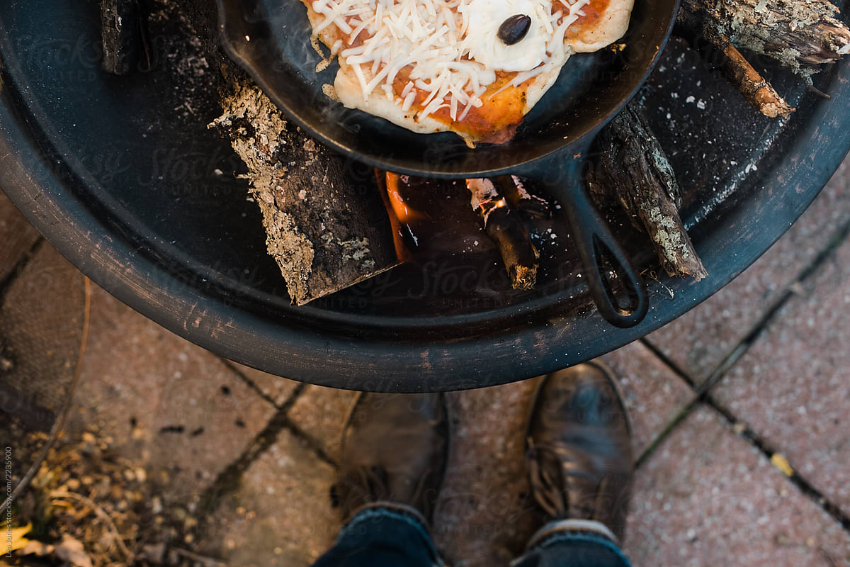 "Pizza Cooking On A Fire Pit" by Stocksy Contributor "Lea Jones" - Stocksy
