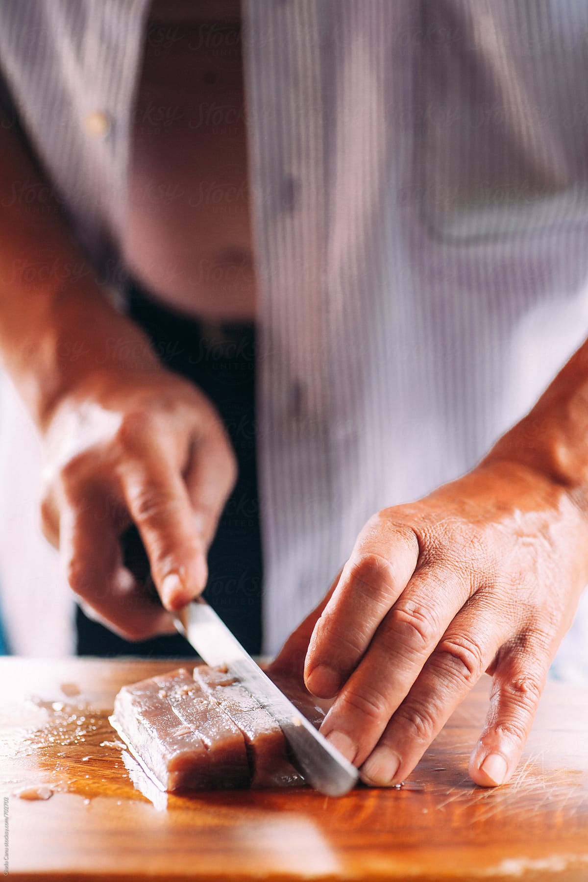 "Man Cutting Tuna" by Stocksy Contributor "Giada Canu" - Stocksy
