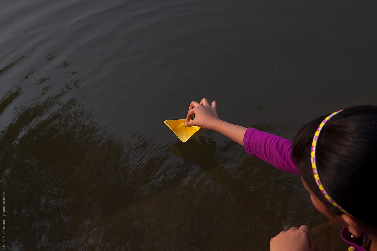 "Teenage Girl Sailing Paper Made Boat Floating On Water" by Stocksy ...