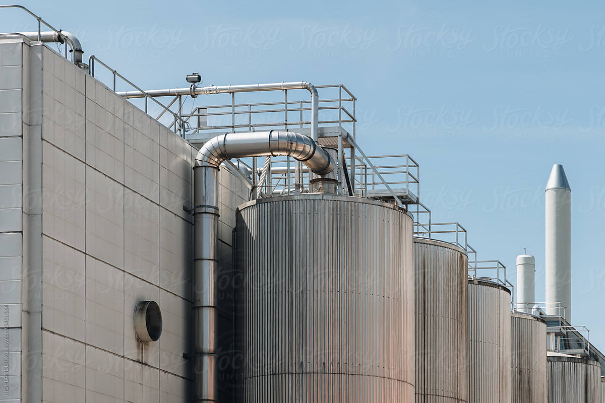 "Industrial Silos Under Clear Sky" by Stocksy Contributor "Zoran Djekic ...