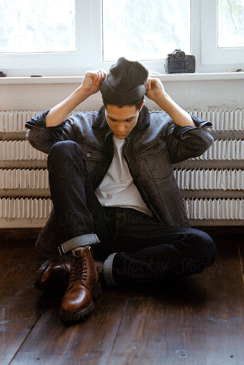 "Man Putting On Hat" by Stocksy Contributor "Danil Nevsky" - Stocksy