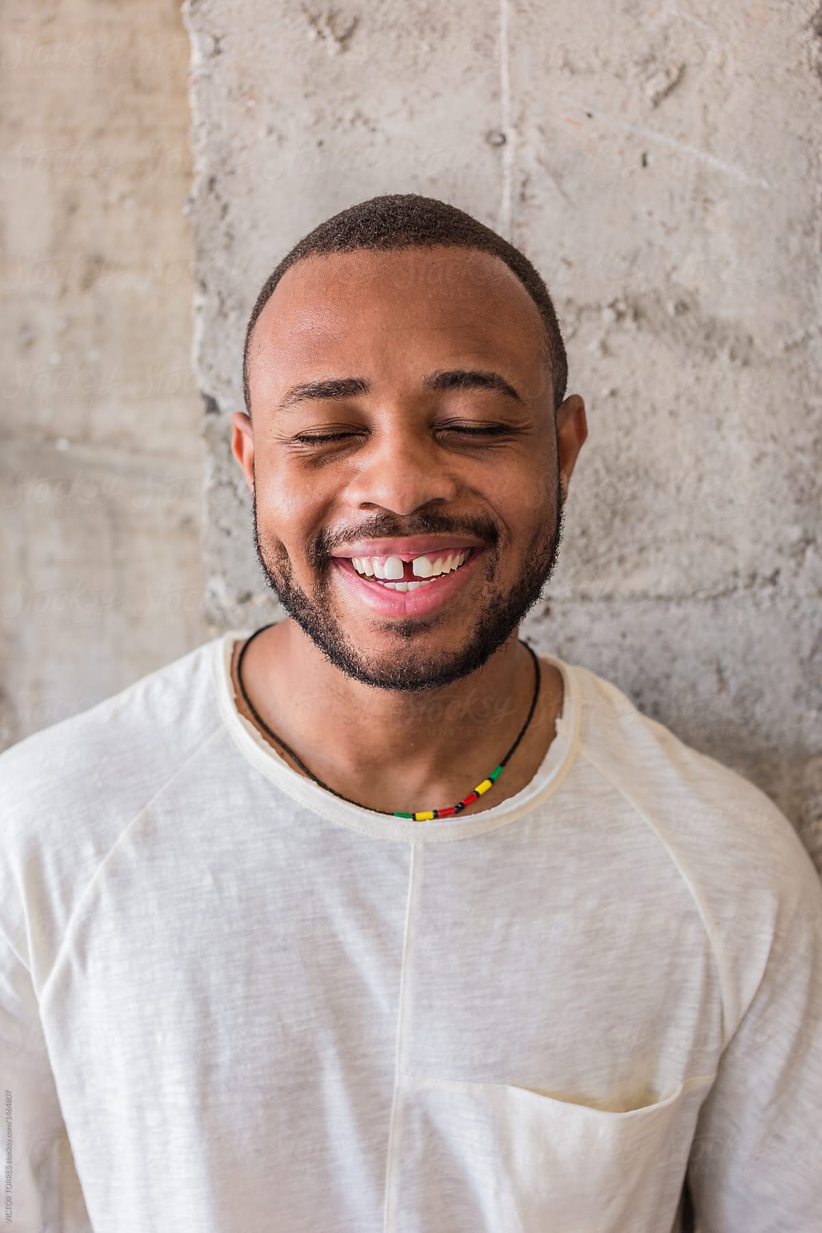 "Laughing Black Man" by Stocksy Contributor "VICTOR TORRES" - Stocksy