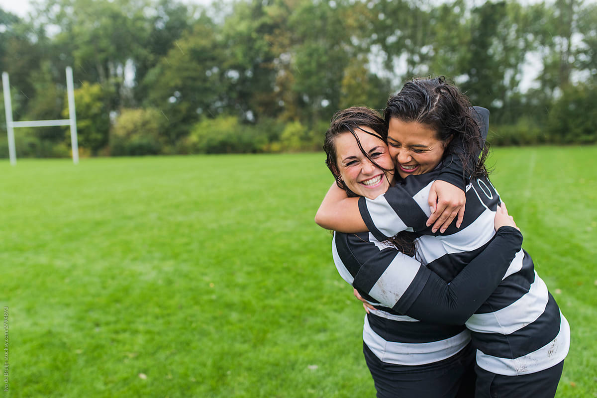 "Two Female Rugby Teammates Hugging, While Standing On The Field" by ...