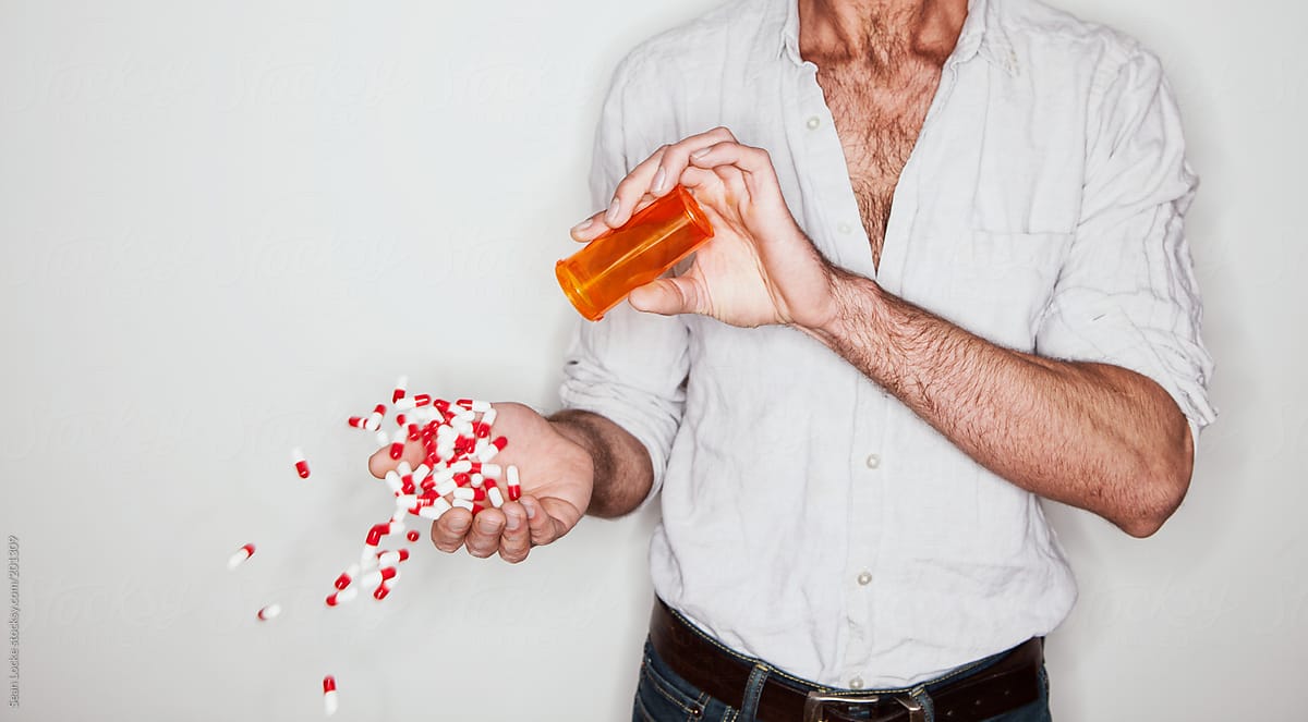 "Man Dumping Capsules Out Into Hand" by Stocksy Contributor "Sean Locke ...