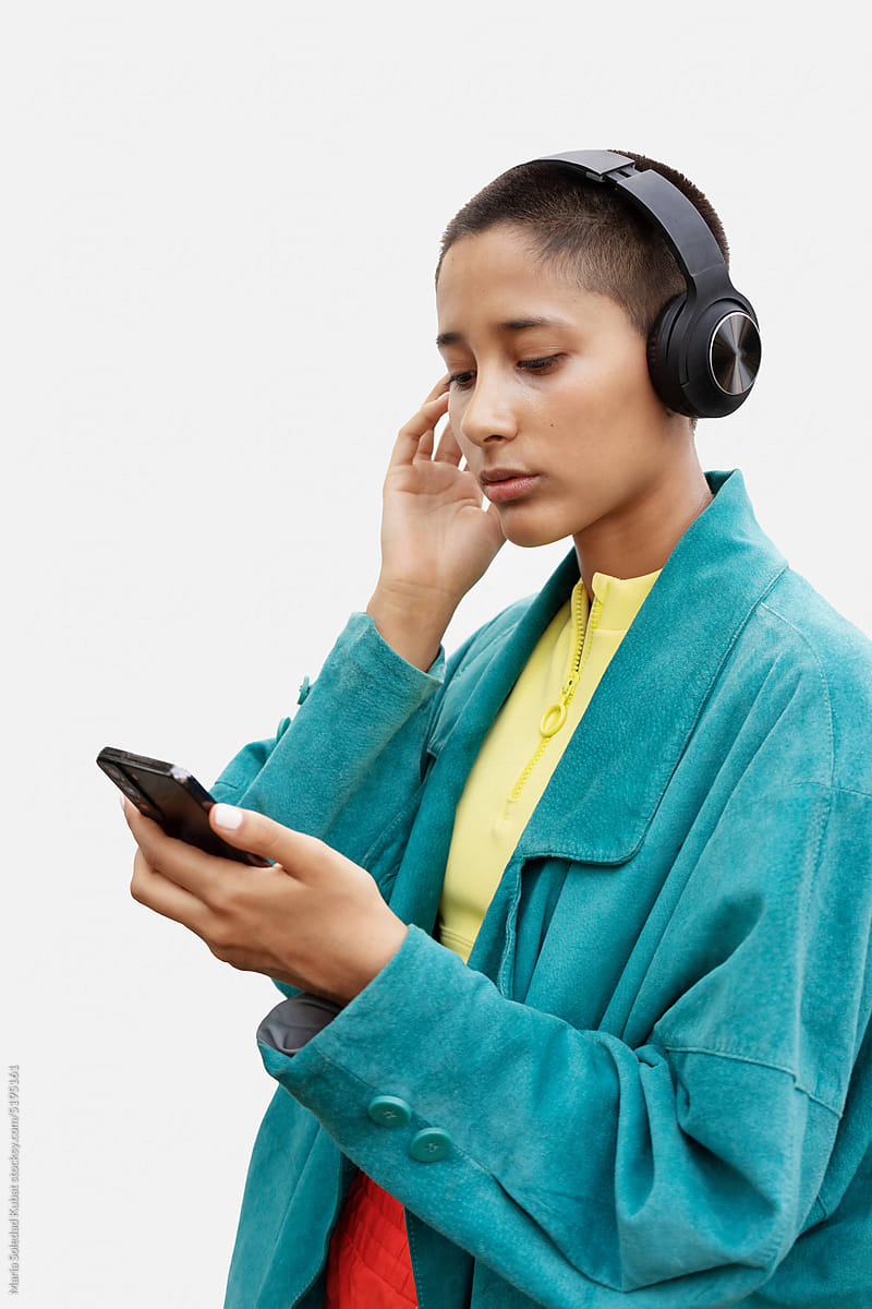 "Young Woman With Shaved Head With Headphones And Cellphone" by Stocksy ...