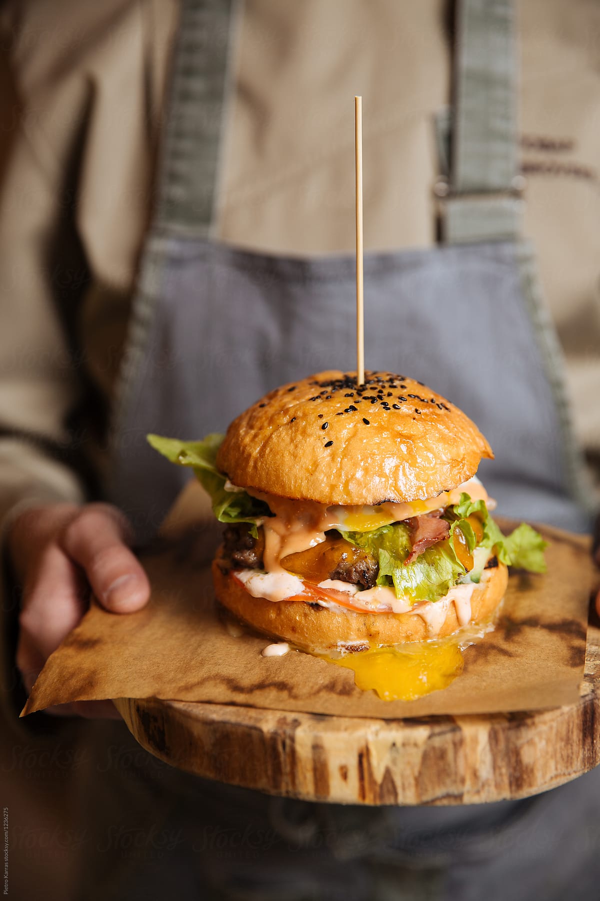 "Male Chef Holding Wooden Slab With Big Burger" by Stocksy Contributor ...