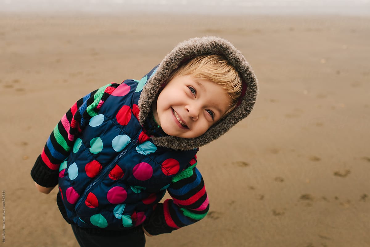 "Happy, Cheeky Smiling Girl In Colourful Winter Clothes On A Beach." by ...