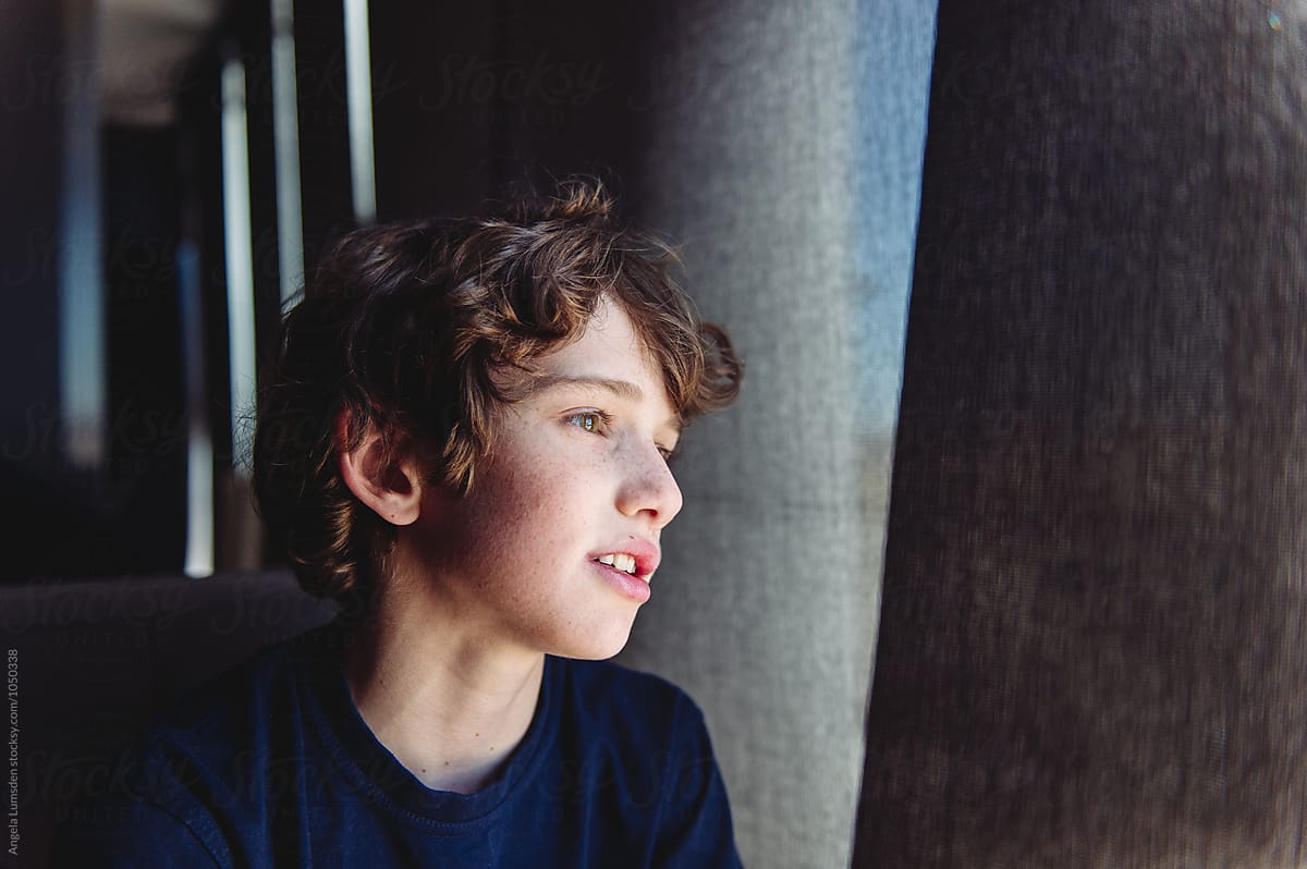 "Close Up Portrait Of A Teenage Boy By A Large Shaded Window At An ...