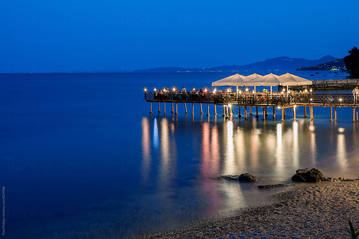 "Illuminated Old Pier At Night With Bar Area. Blue Sky And Sea." by ...