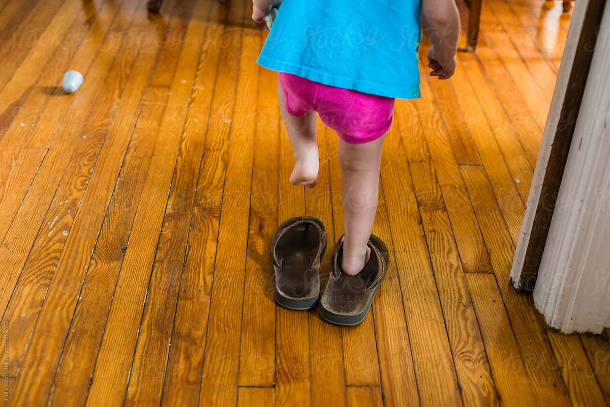 "Young Girl Steps Into Father's Shoes On Hardwood Floor" by Stocksy ...