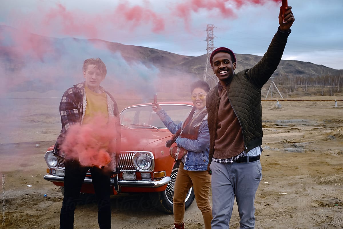 "Cheerful Friends With Smoke Grenades" by Stocksy Contributor "Clique ...