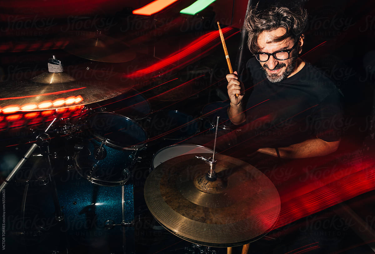 "Passionate Drummer Performing On Stage With Vibrant Lights" by Stocksy ...