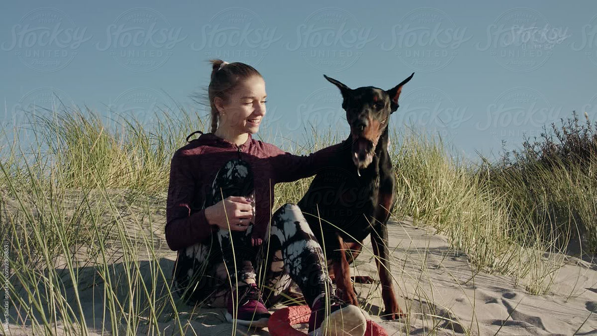 "Girl With Barking Dog Sitting On Sand" by Stocksy Contributor "Milles ...