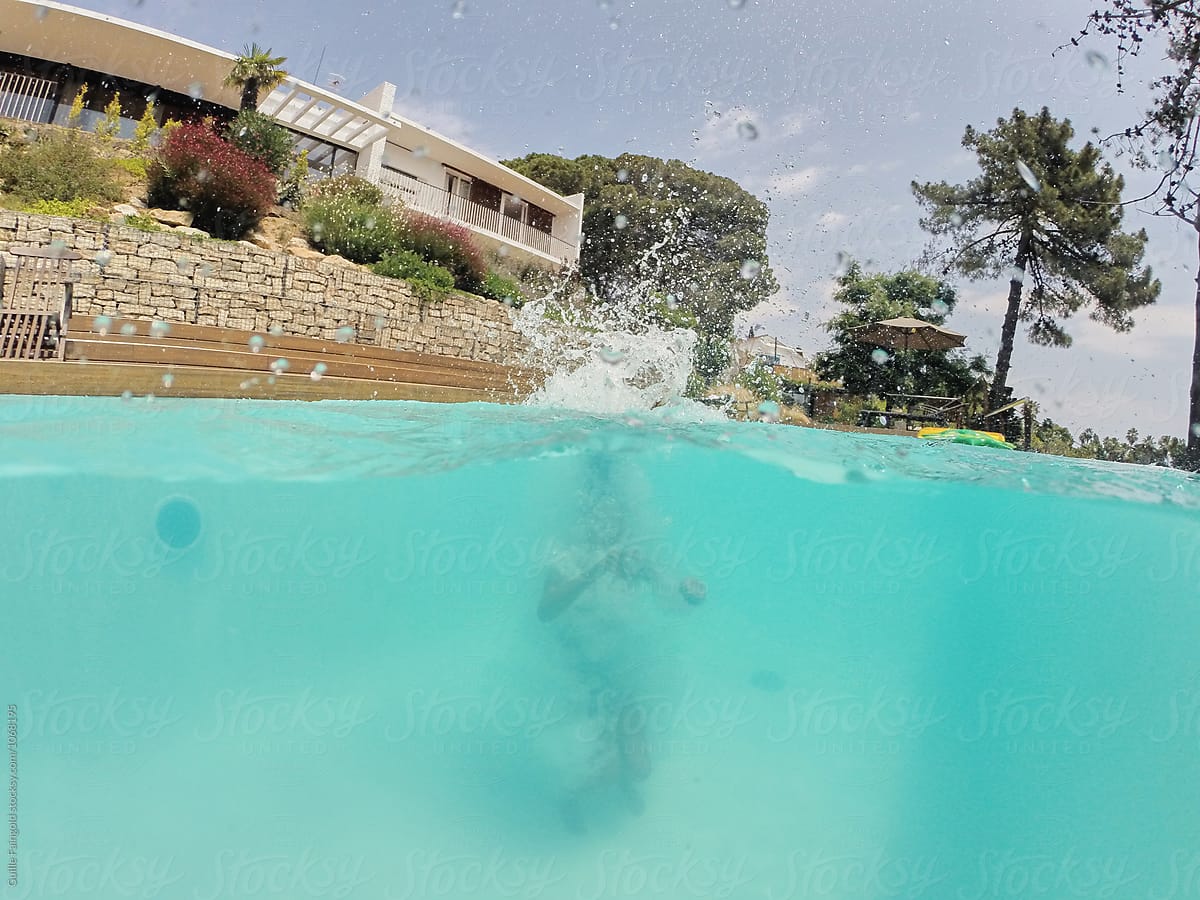 "Summer Jumping In Pool" by Stocksy Contributor "Guille Faingold" - Stocksy
