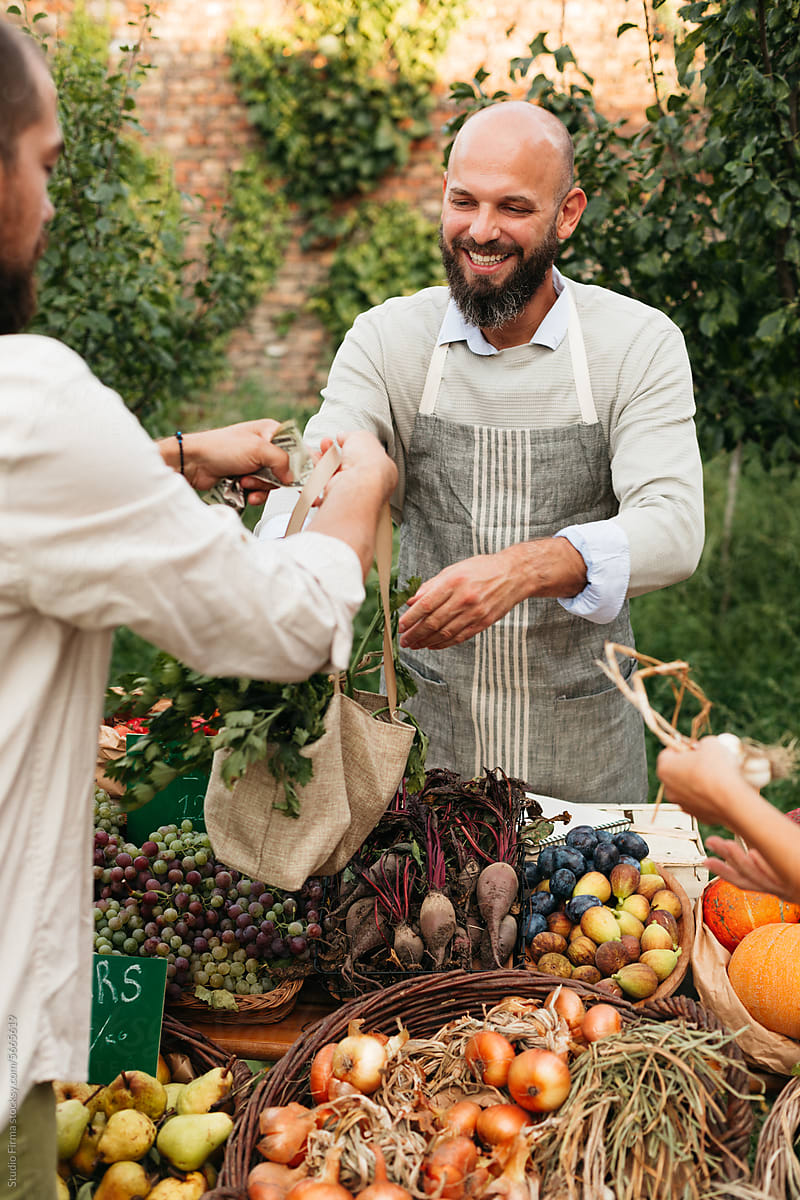 "Man Selling At Farmer's Market" by Stocksy Contributor "Studio Firma ...