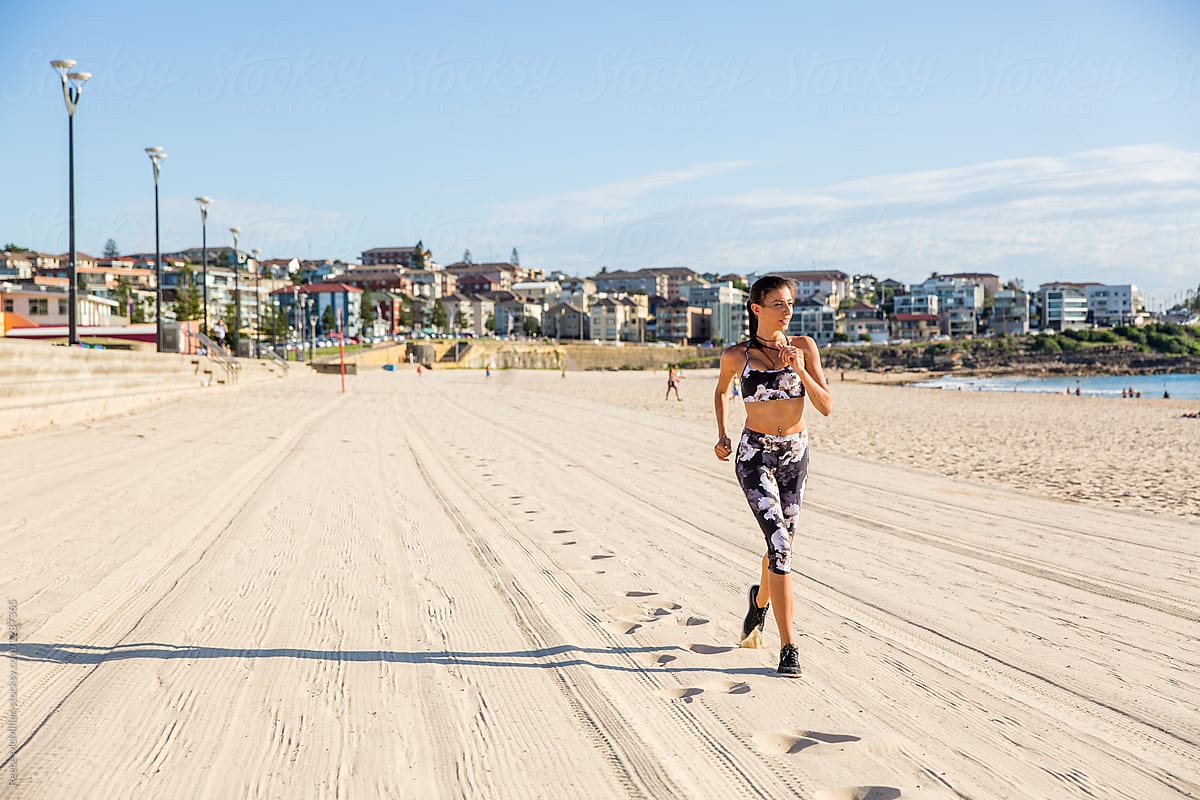 "A Fit Woman Running Along The Beach" by Stocksy Contributor "Reece ...