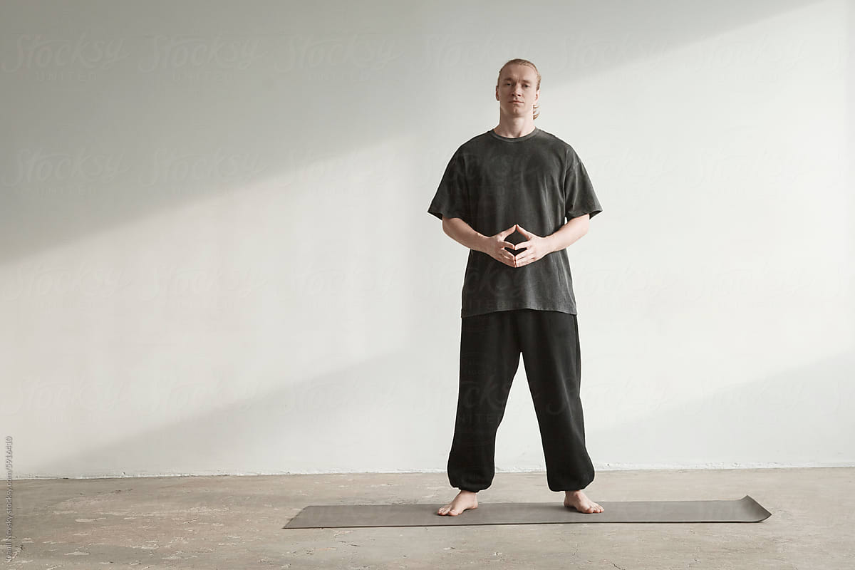 "Young Man Standing On Mat During Yoga Practice Break" by Stocksy ...