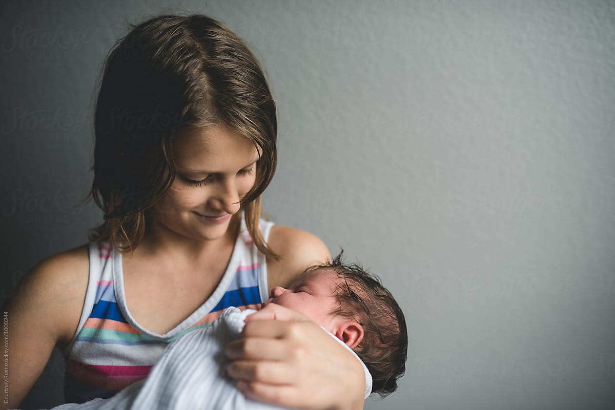 "Tween Girl Holds New Baby Sister" by Stocksy Contributor "Courtney ...