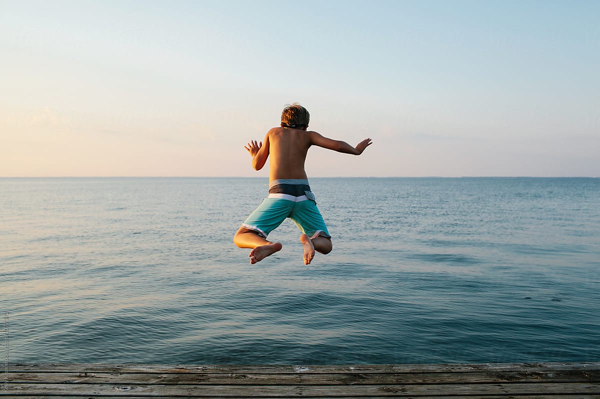 "Boy Jumping Off Of A Pier Into A Lake At Sunset" by Stocksy ...