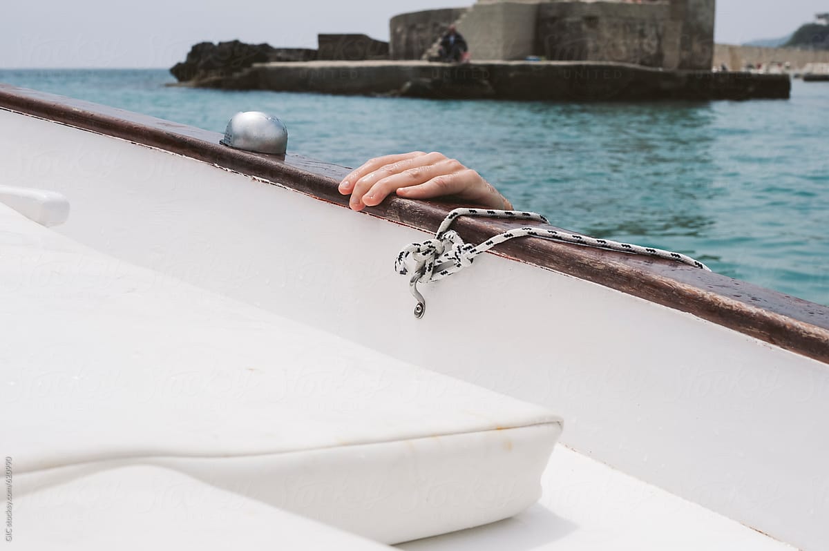 "Hand Gripping The Boat" by Stocksy Contributor "Koganami Studio" - Stocksy