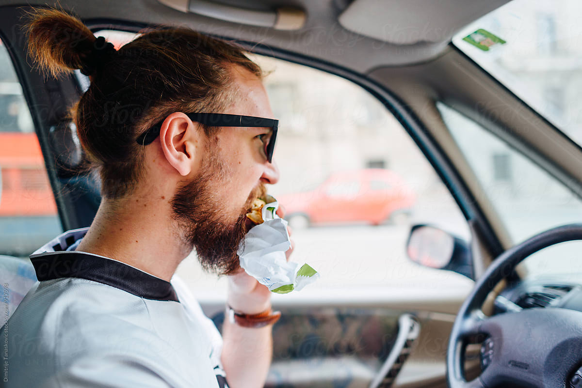 "Man Eating In The Car" by Stocksy Contributor "Dimitrije Tanaskovic ...