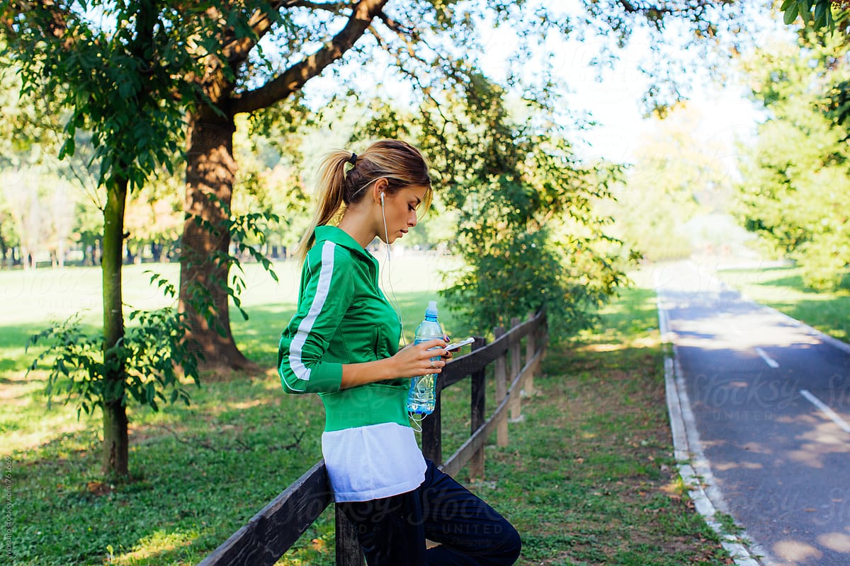 "Female Runner Checking Phone In The Park" by Stocksy Contributor ...