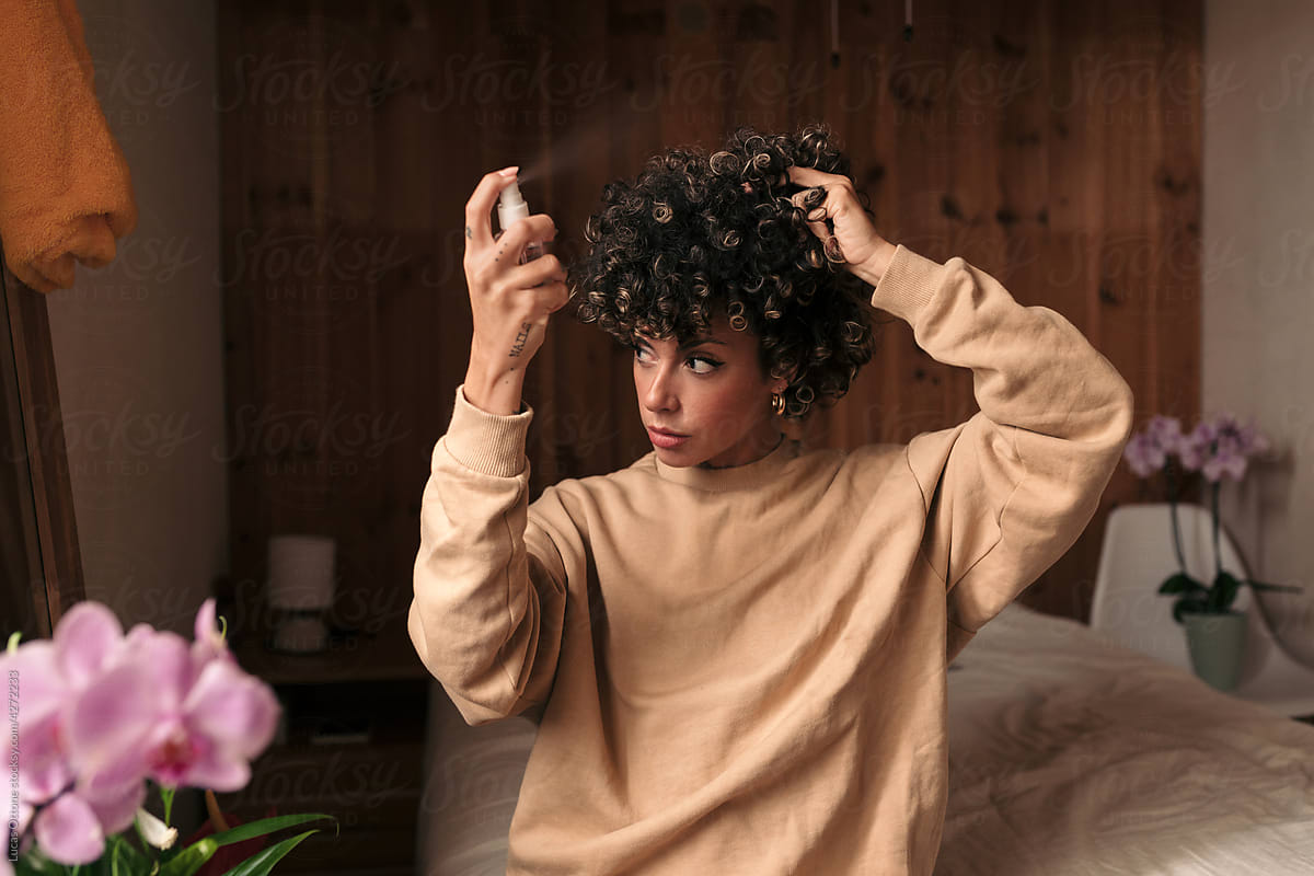"Woman Spraying Her Hair" by Stocksy Contributor "Lucas Ottone" - Stocksy