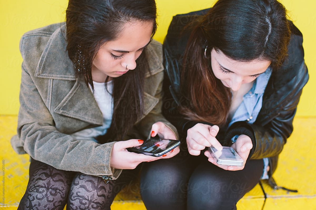 "Two Girls Using Their Mobile Phone" by Stocksy Contributor "Michela ...