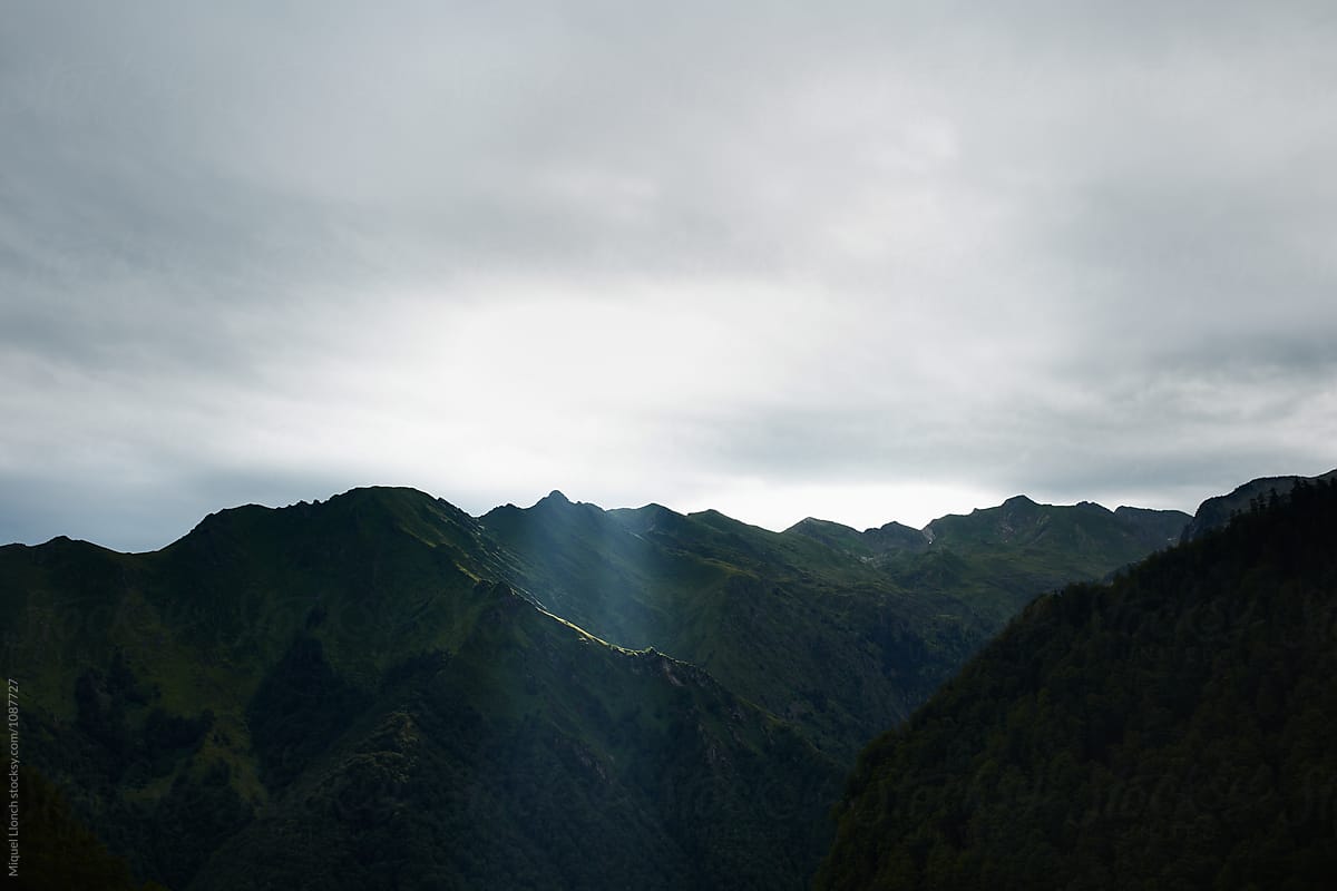 "A Sunlight Ray In A Mountain Range" by Stocksy Contributor "Miquel ...